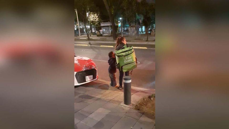 Captan a mujer repartiendo comida a pie junto a su supuesto hijo ...